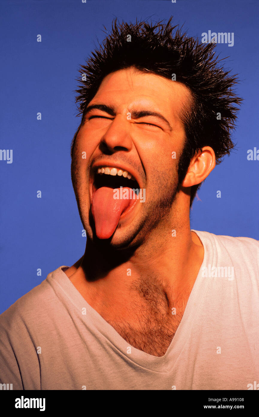 Young man sticking his tongue out Stock Photo - Alamy