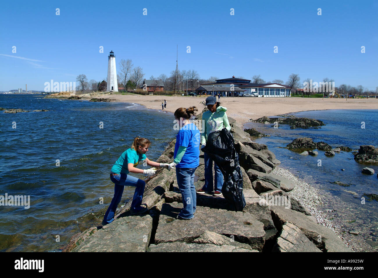 Volunteers clean up a beach next to a lighthouse in New Haven ...