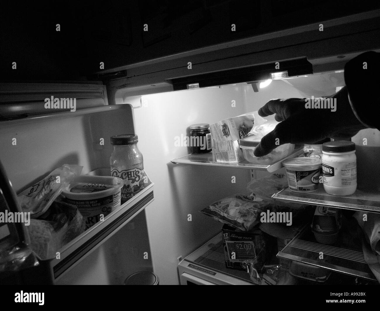 A hand reaches for food inside a home refrigerator Stock Photo - Alamy
