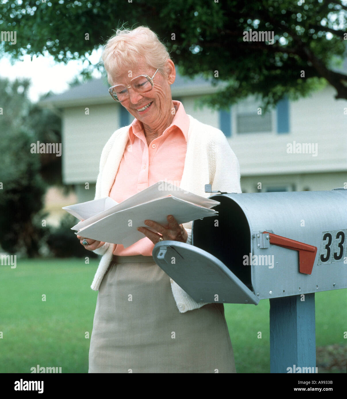 mature woman collecting cards and letters from mailbox Stock Photo - Alamy