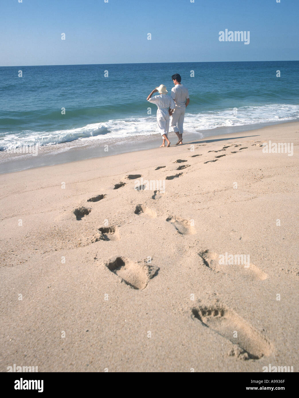 couple leaving footprints in the sand at the beach Stock Photo - Alamy