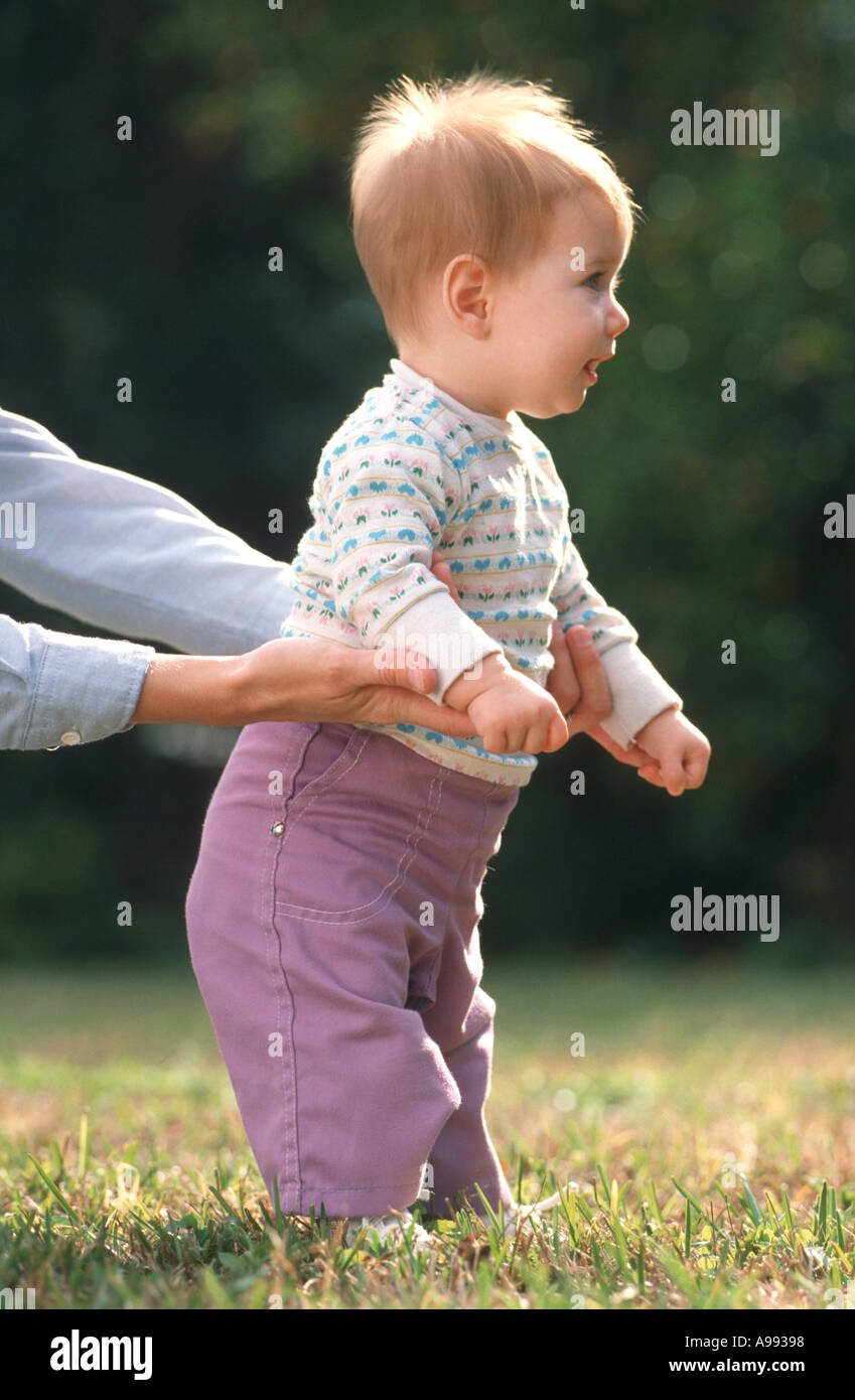 baby taking first steps being helped by mother Stock Photo - Alamy