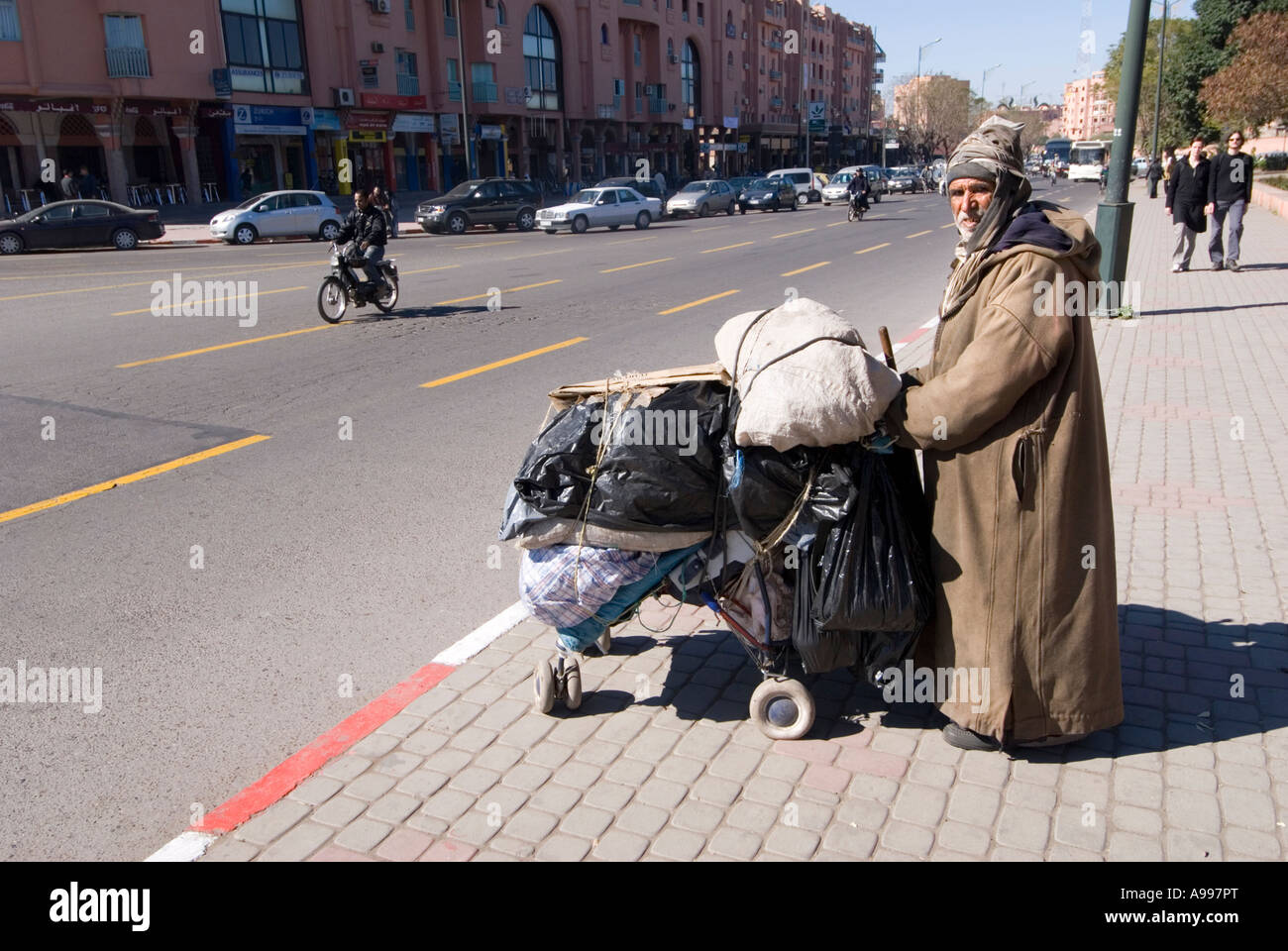 Portrait of a homeless Moroccan man with his pocessions in a push chair ...