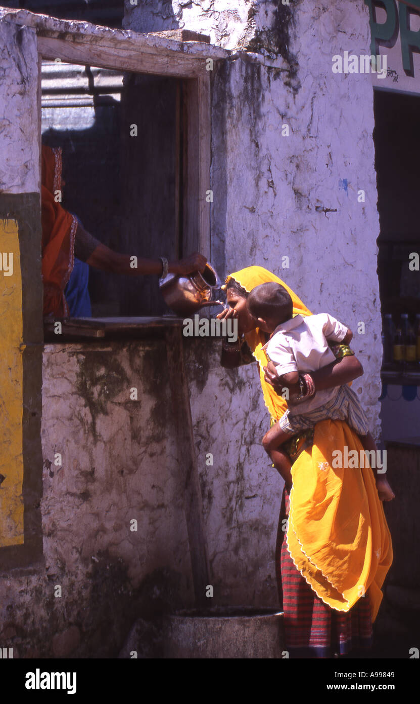 India Woman giving drink to mother and baby Stock Photo - Alamy