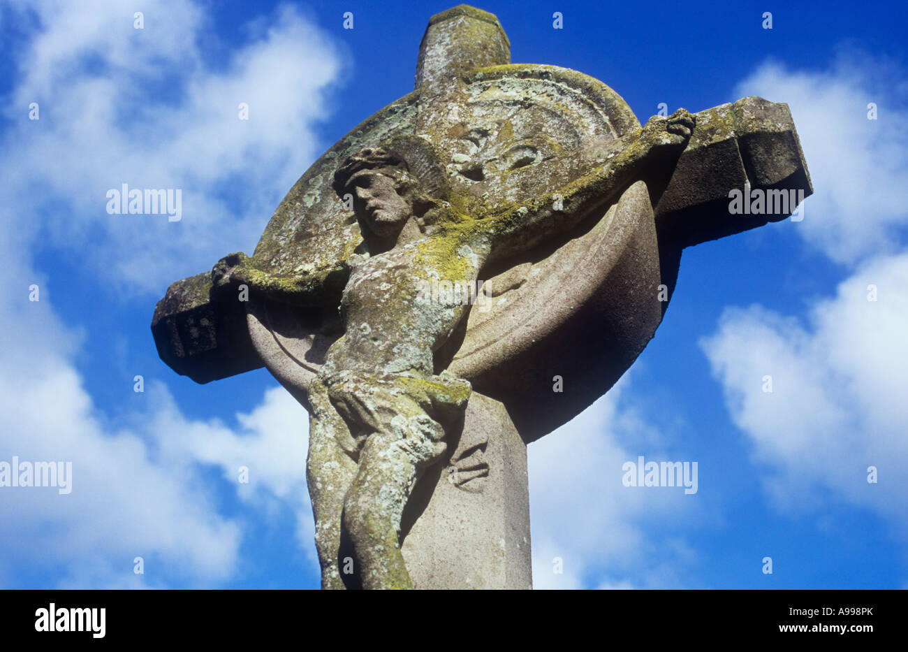 Detail of lichen-covered cement Jesus Christ on Celtic crucifix with ...