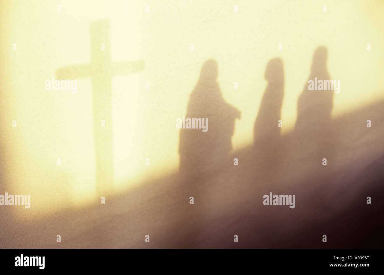 Shadow in warm light on pale cloth of three figures in cloaks and ...