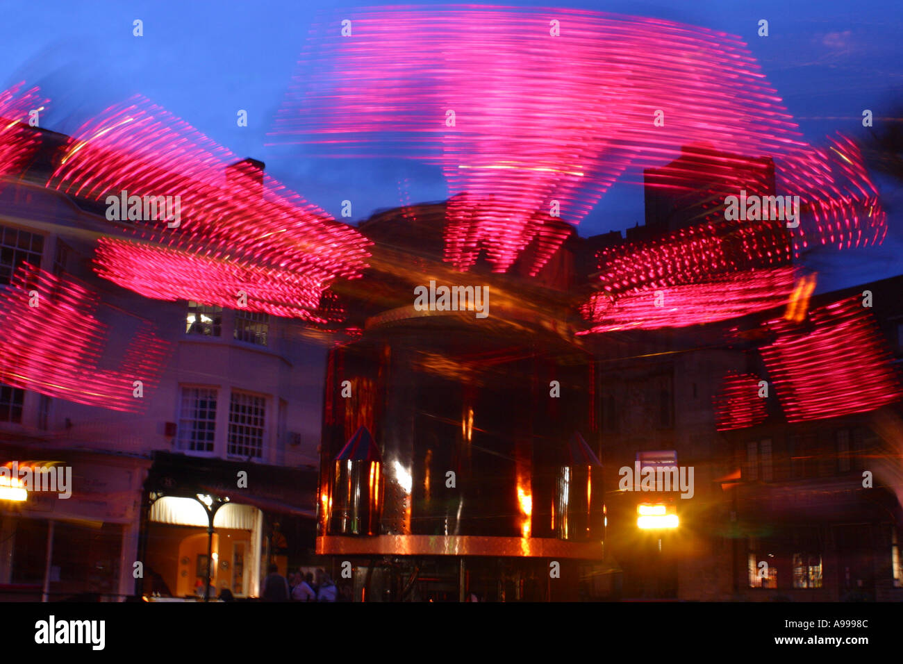 Funfair ride at night blurred lighting Stock Photo - Alamy