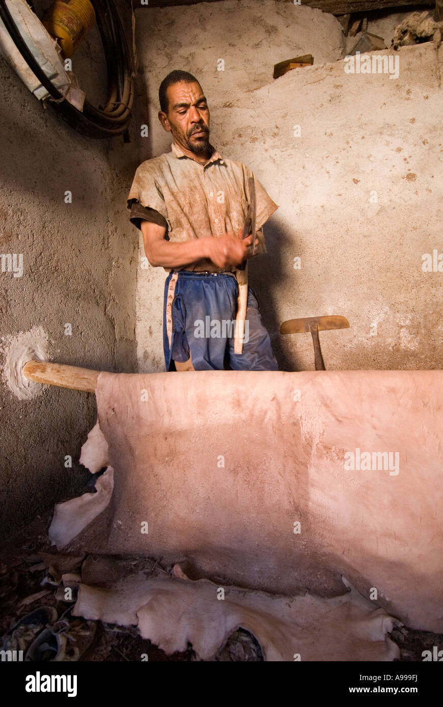 Tanner sharpening tool between scraping a dry hide clean at the Bab ...