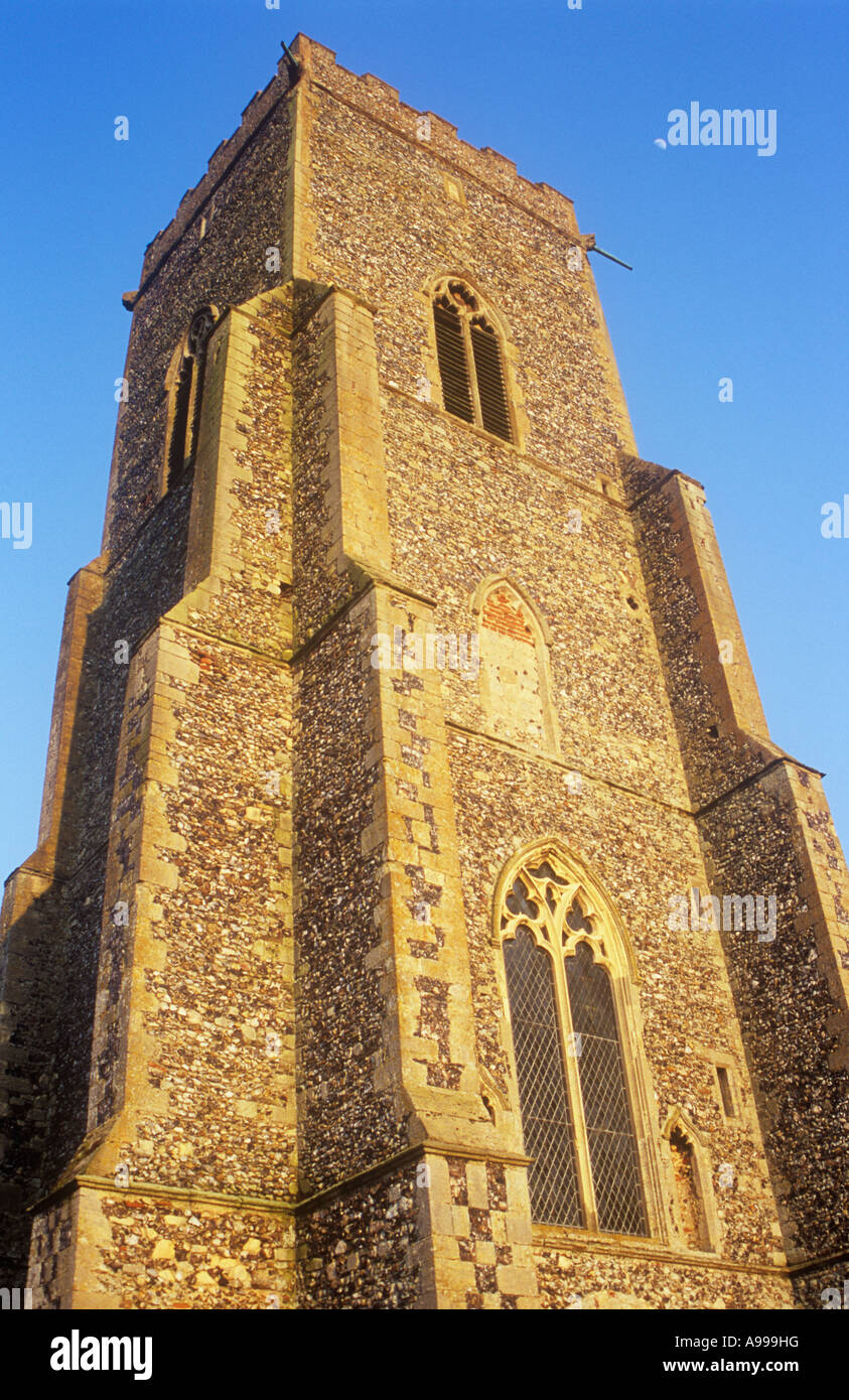 View from below of buttressed square church tower built with knapped ...
