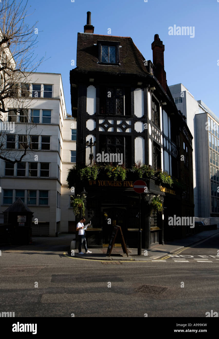 Man reading newspaper outside "The Coach and Horses" "Olde worlde" pub ...