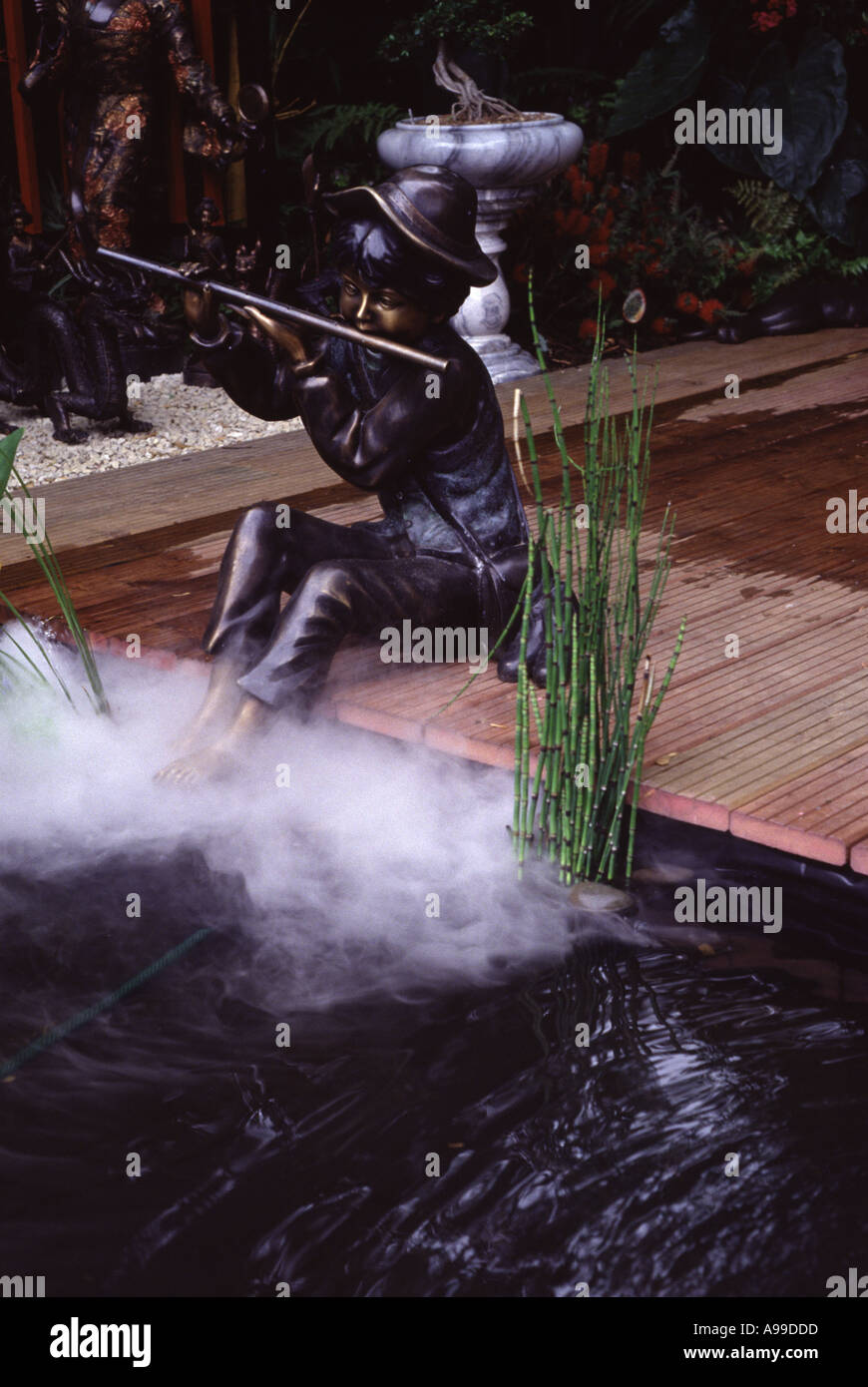 Flute playing Statue with smoke effect at feet by pool Chelsea Flower ...