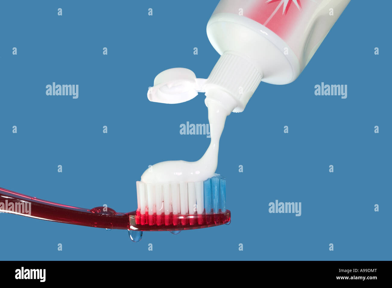 Toothpaste being applied to a red toothbrush Stock Photo - Alamy