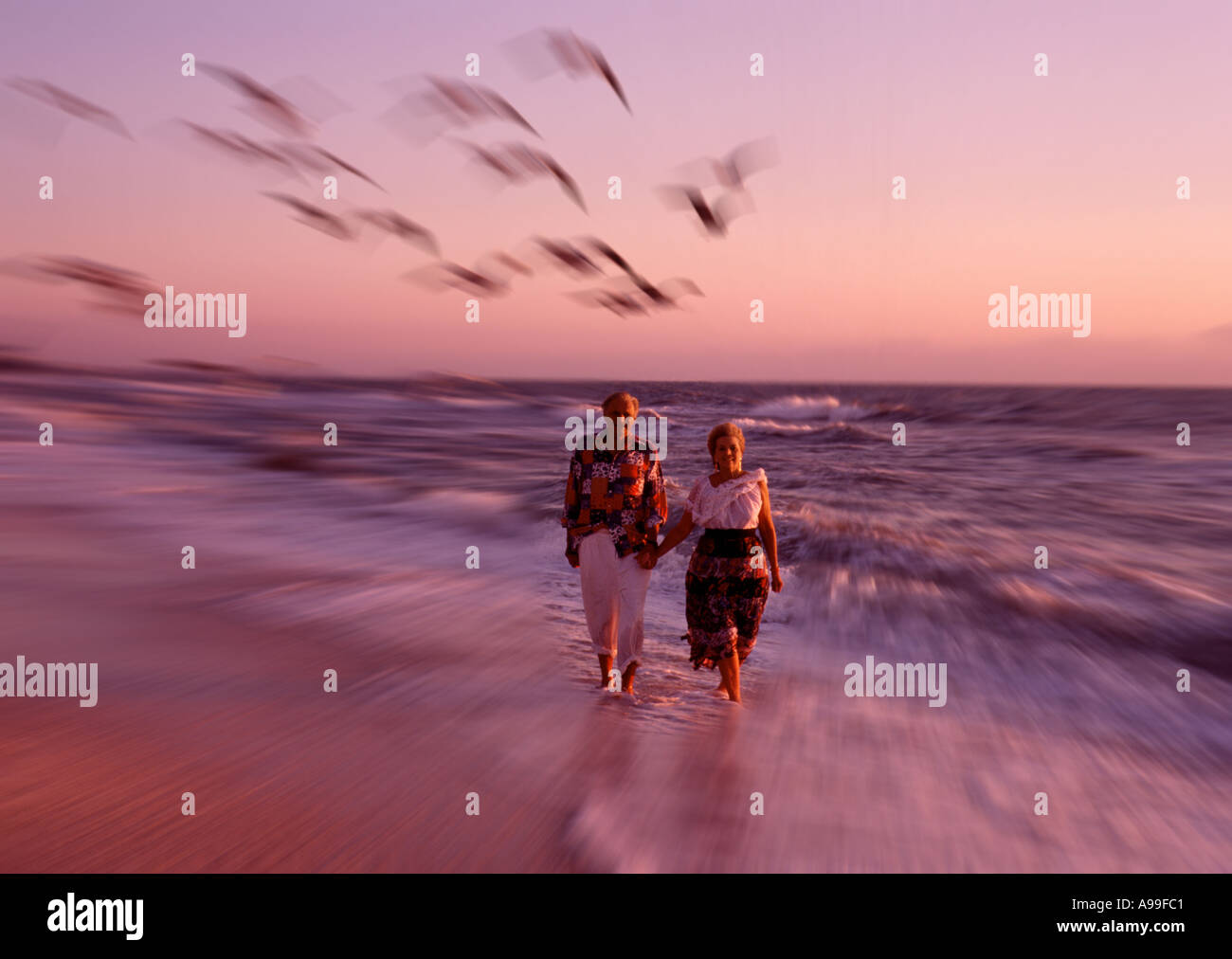 Retired couple relaxing on the beach Stock Photo - Alamy