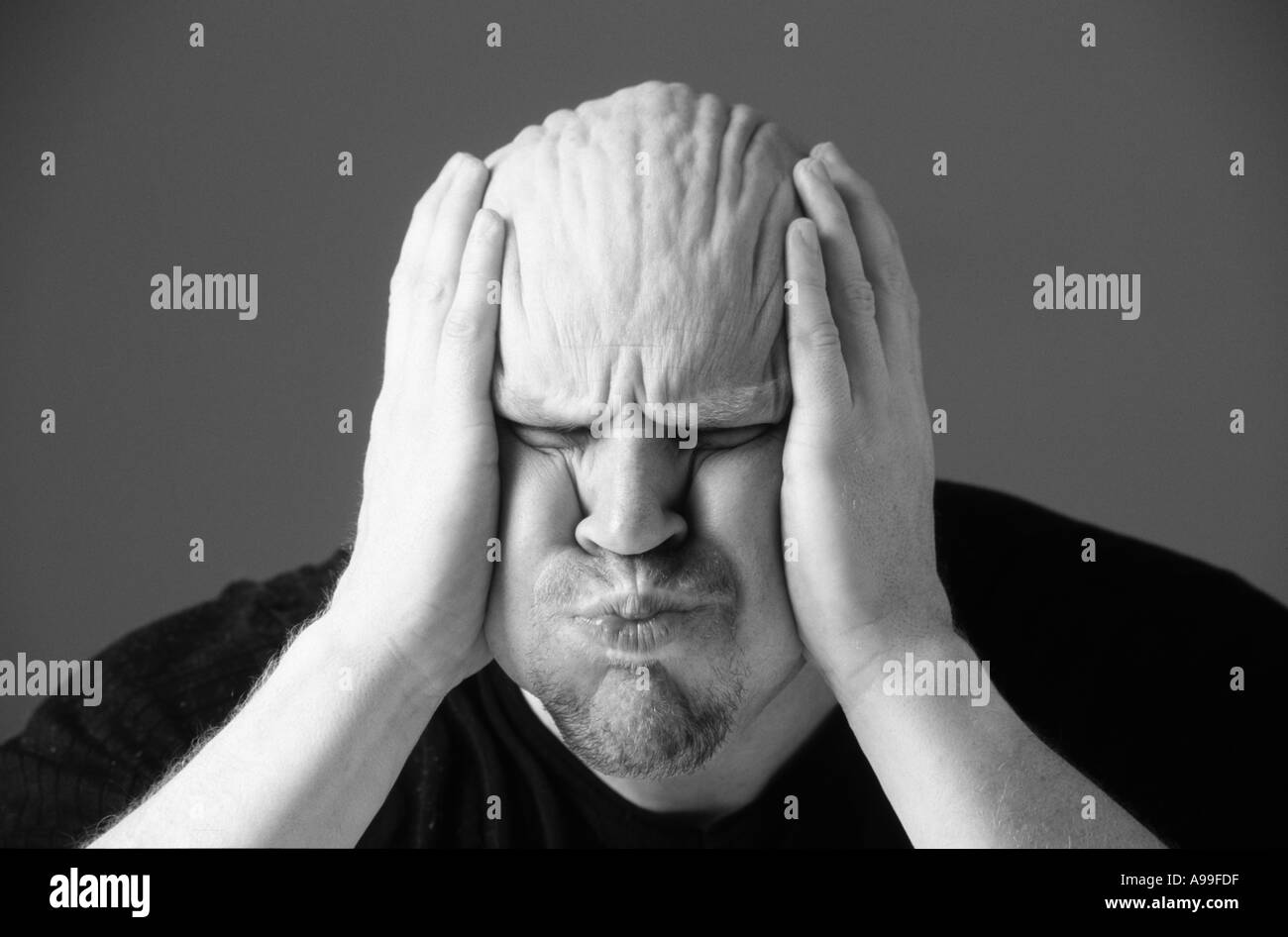 bald man squeezing his head Stock Photo - Alamy
