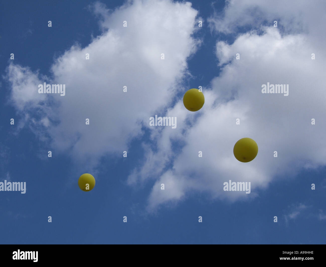yellow balloons floating in blue sky Stock Photo - Alamy