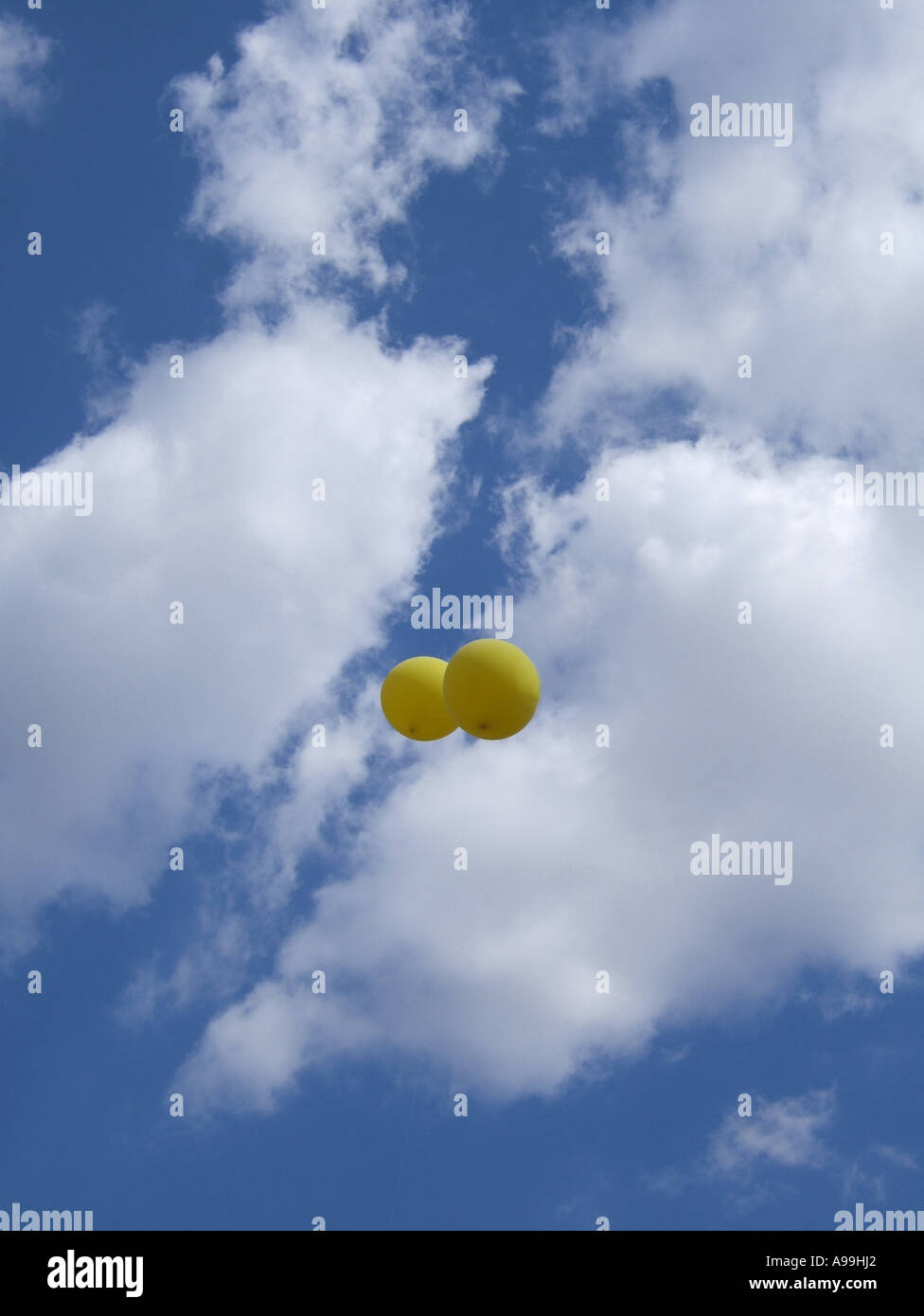 yellow balloons floating in blue sky Stock Photo - Alamy