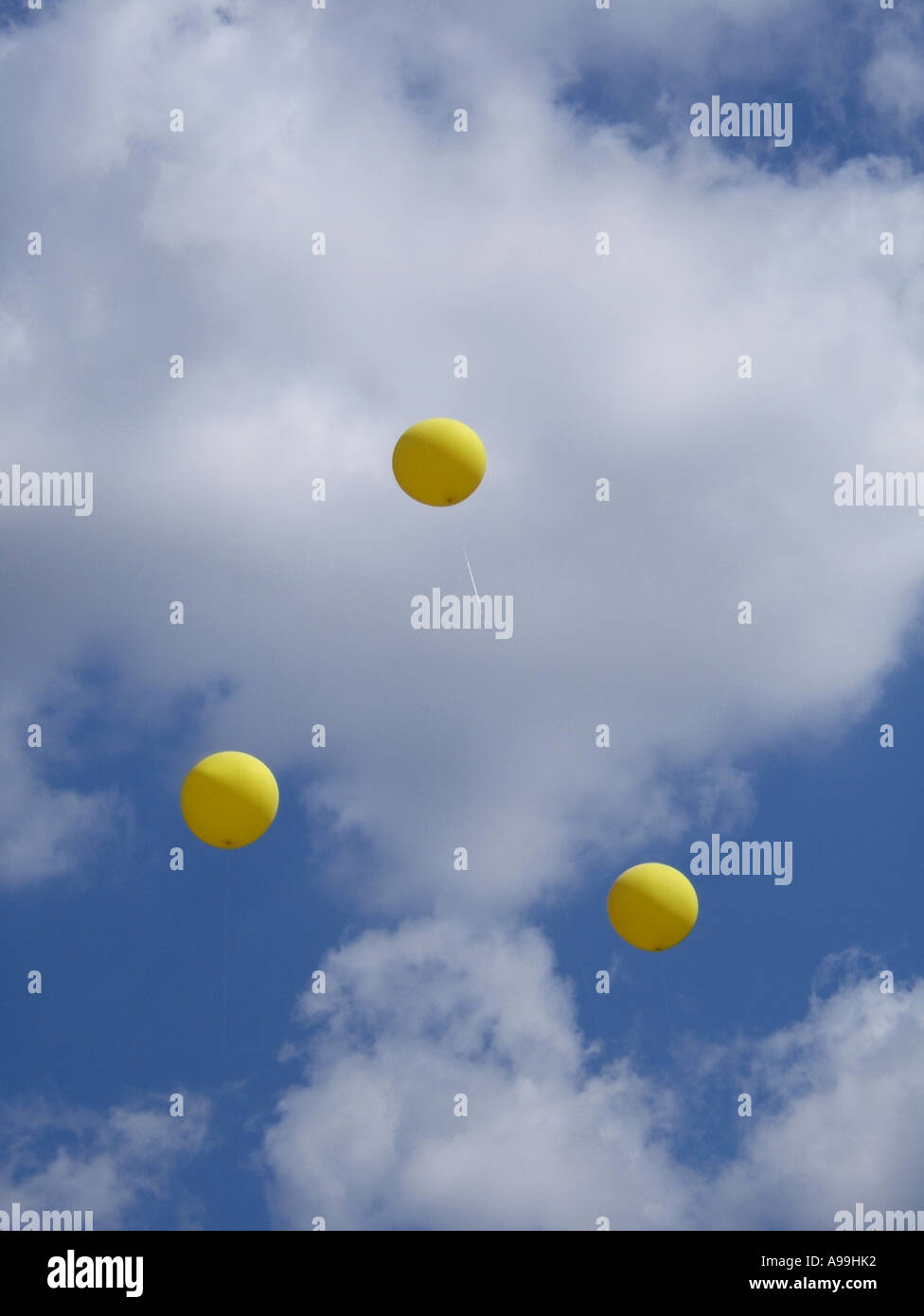 yellow balloons floating in blue sky Stock Photo - Alamy