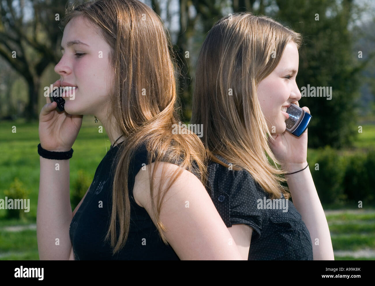 Two girls using mobile phones Stock Photo - Alamy