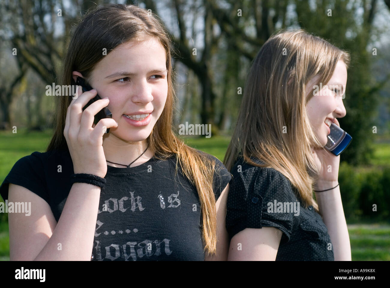 Two girls using mobile phones Stock Photo - Alamy