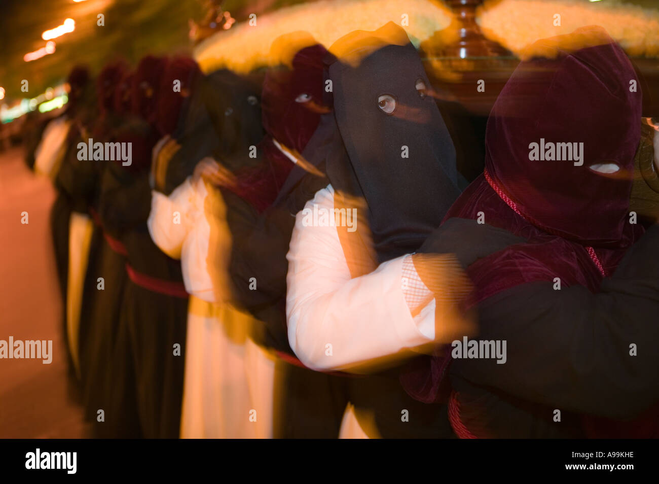Hooded members of a fraternity carry a float during Holy Week ...