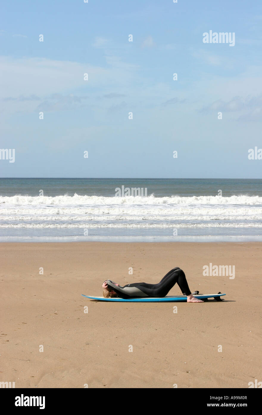 surfer resting from the surf Stock Photo - Alamy