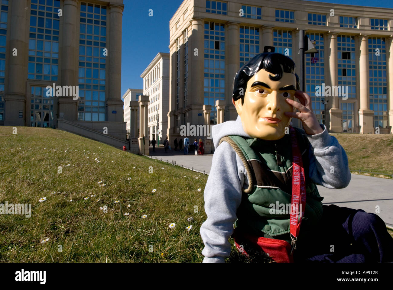 A close up of a child with superman mask sitting on grass in front of ...