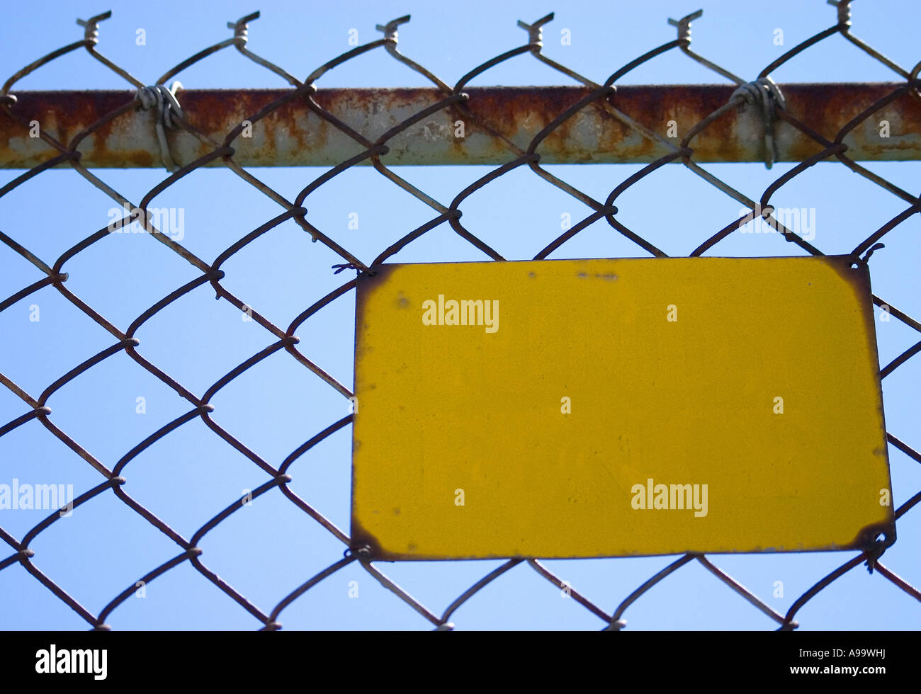 Blank yellow sign on chain link fence Stock Photo - Alamy