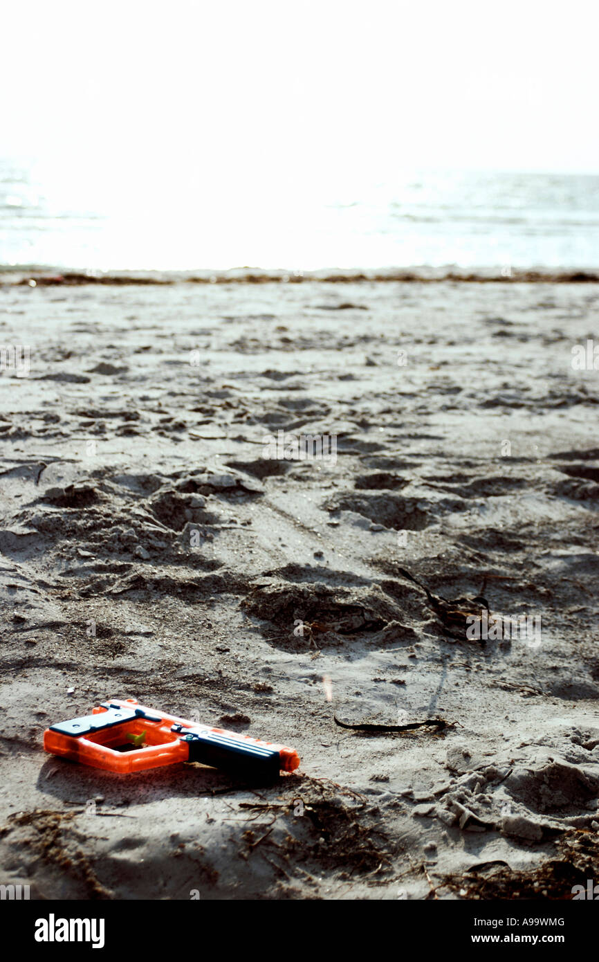 Forgotten toy gun on beach Stock Photo - Alamy