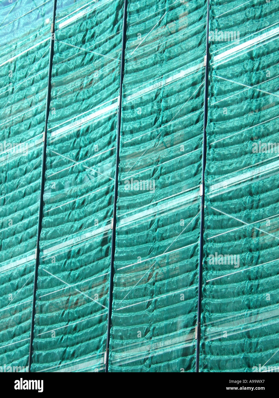 scaffolding with green protective mesh Stock Photo - Alamy