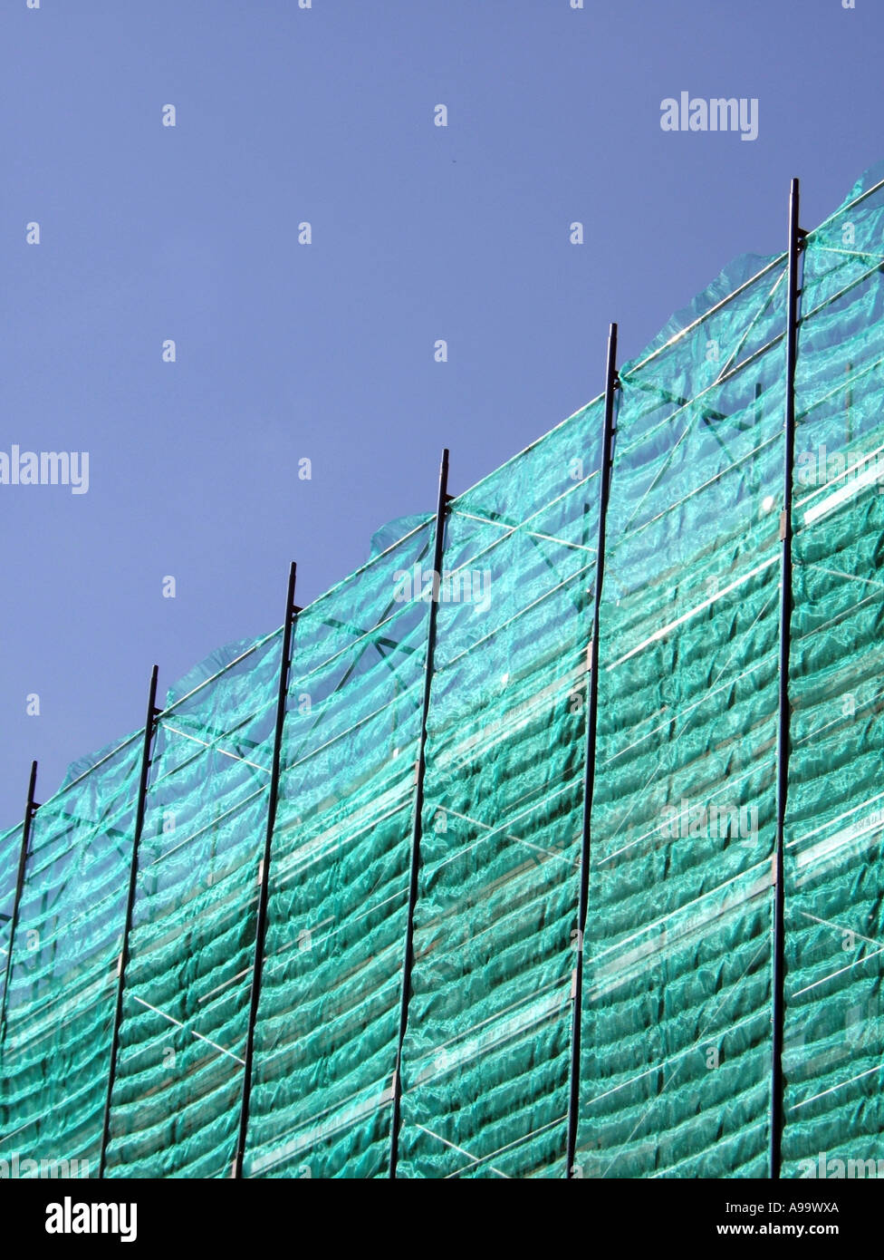 scaffolding with green protective mesh Stock Photo - Alamy