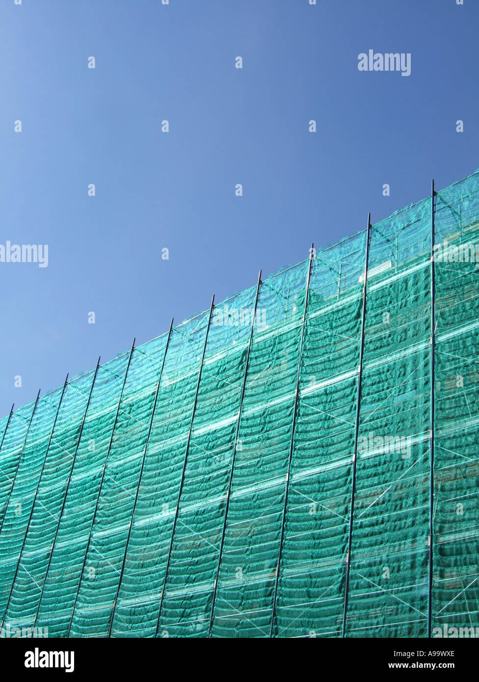 scaffolding with green protective mesh Stock Photo - Alamy