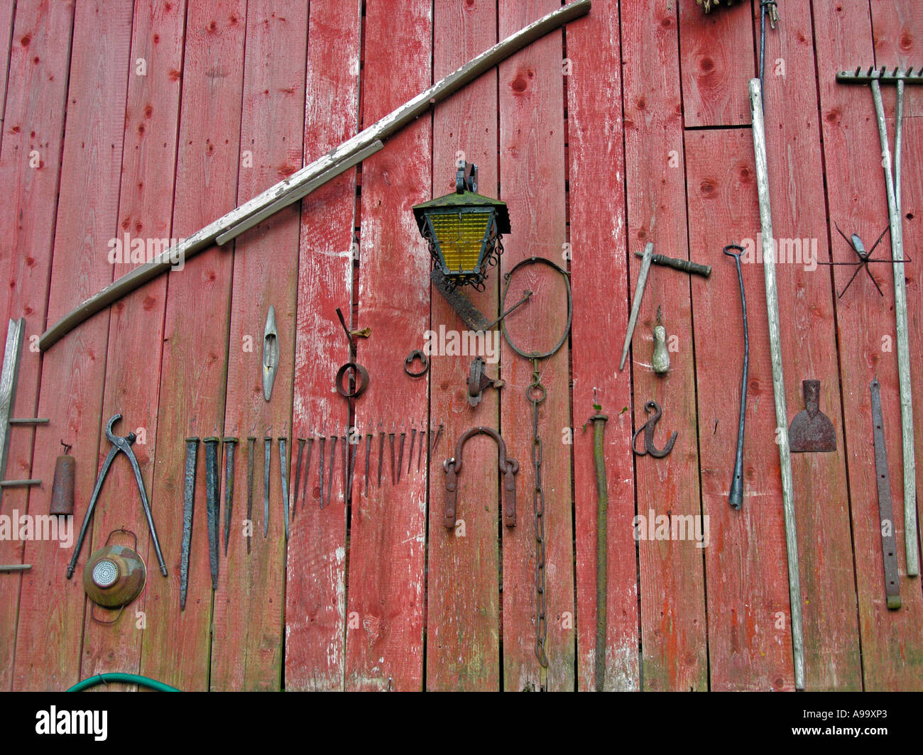 old iron tools and nails on wall of a red blockhouse log house Stock ...