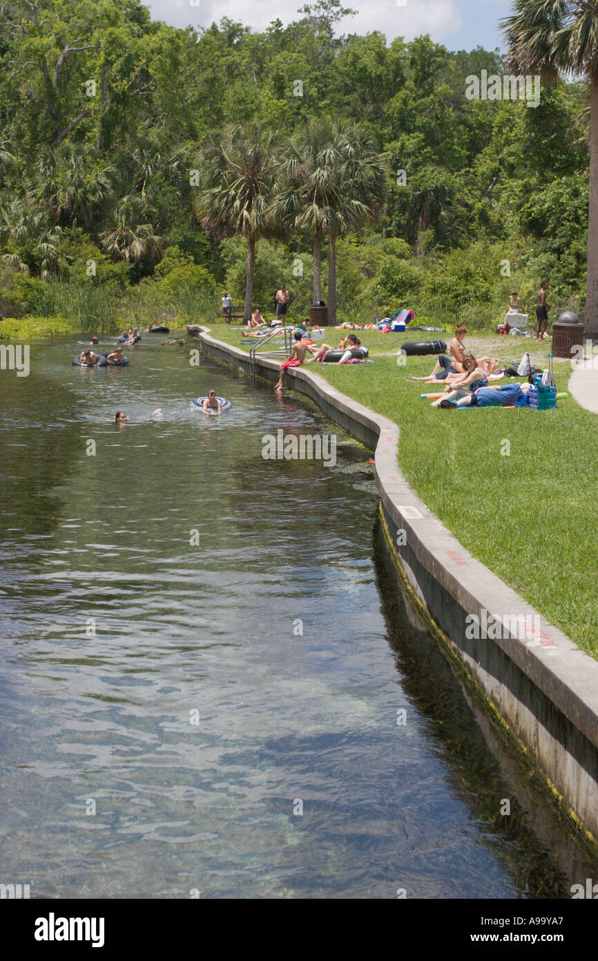 Families enjoy relaxing holiday sunbathing and floating down river on ...