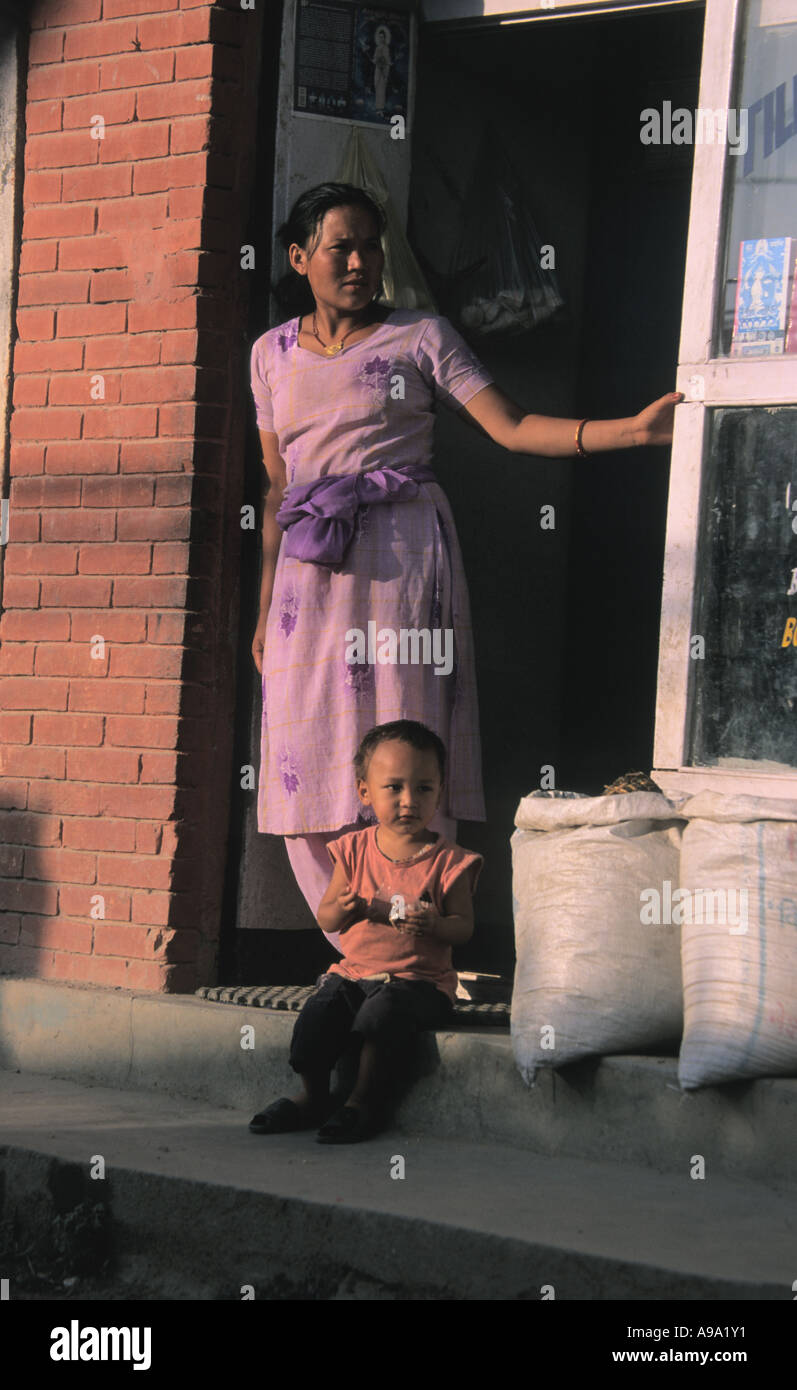 Nepali mother with child at the entrance of a food shop in Kathmandu ...