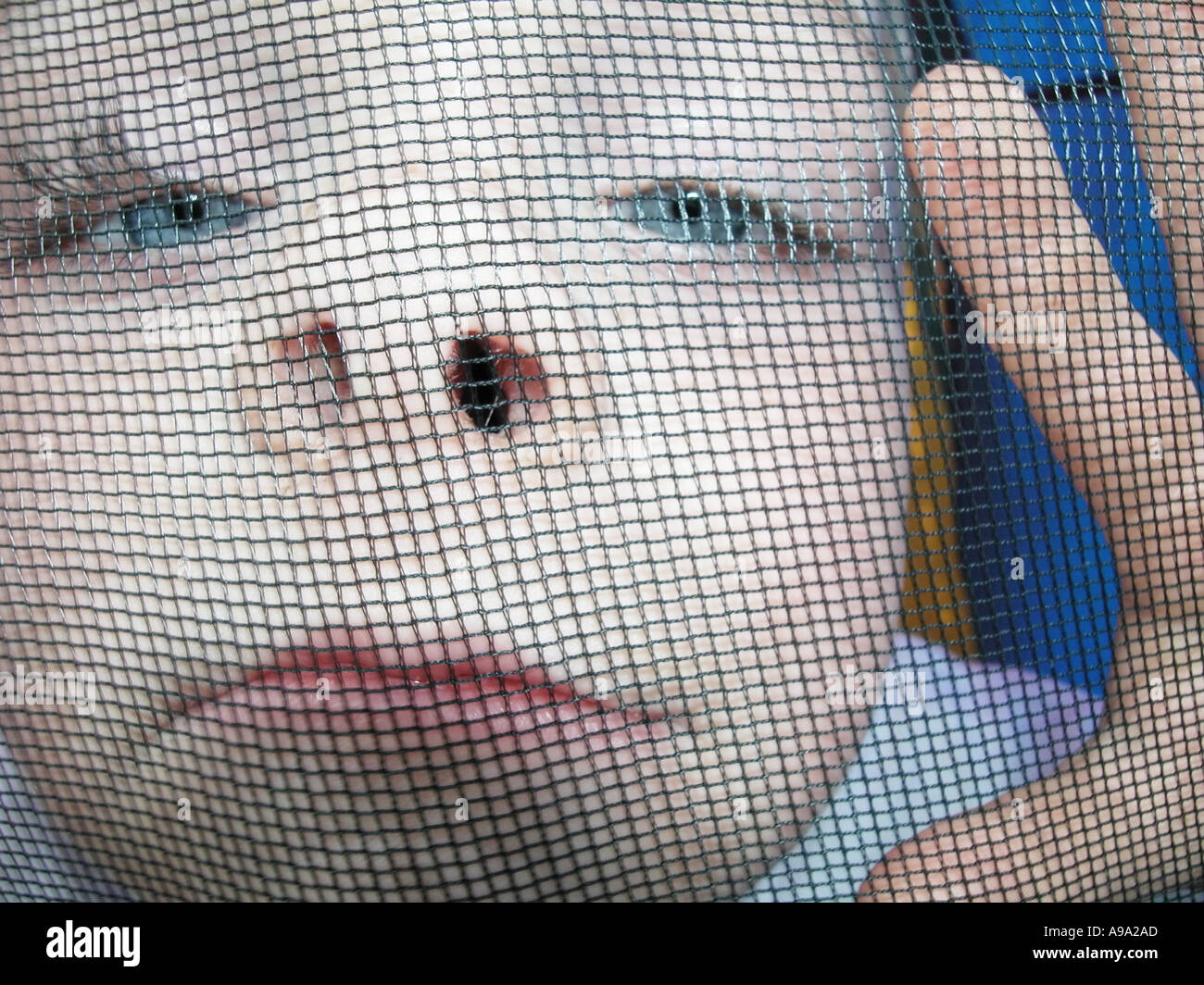 Five year old boy playing behind mesh screen close up portrait Stock ...