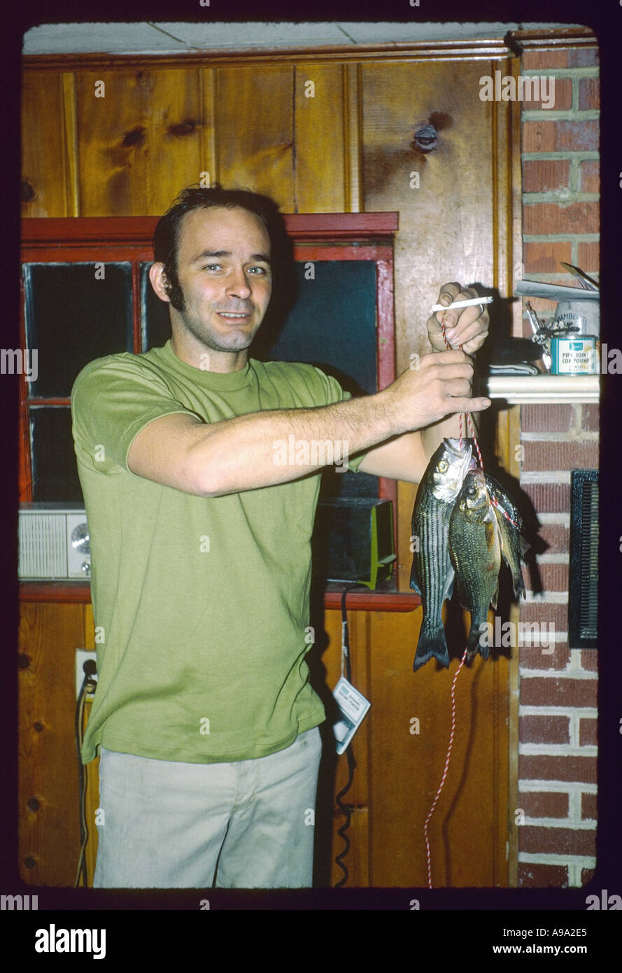 Man holding fish caught while fishing Stock Photo - Alamy