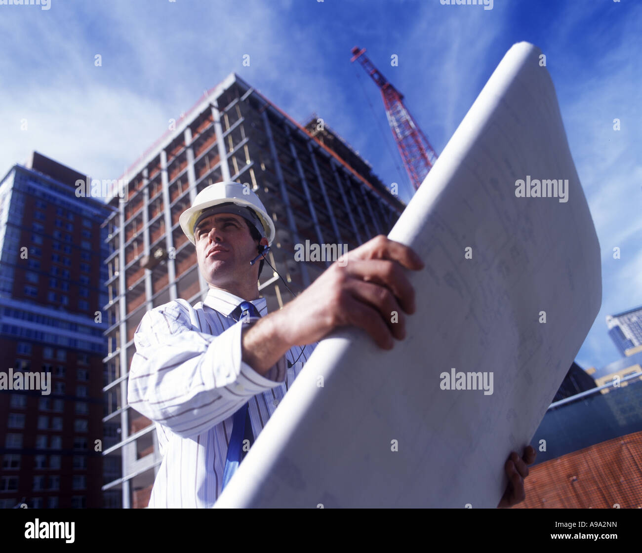 CONSTRUCTION MANAGER AT BUILDING SITE HOLDING BLUEPRINTS Stock Photo ...