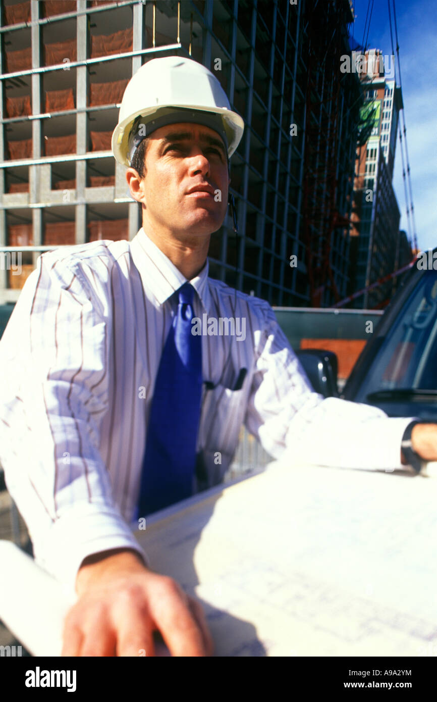 CONSTRUCTION MANAGER OUTDOORS AT BUILDING SITE WITH BLUEPRINTS Stock ...