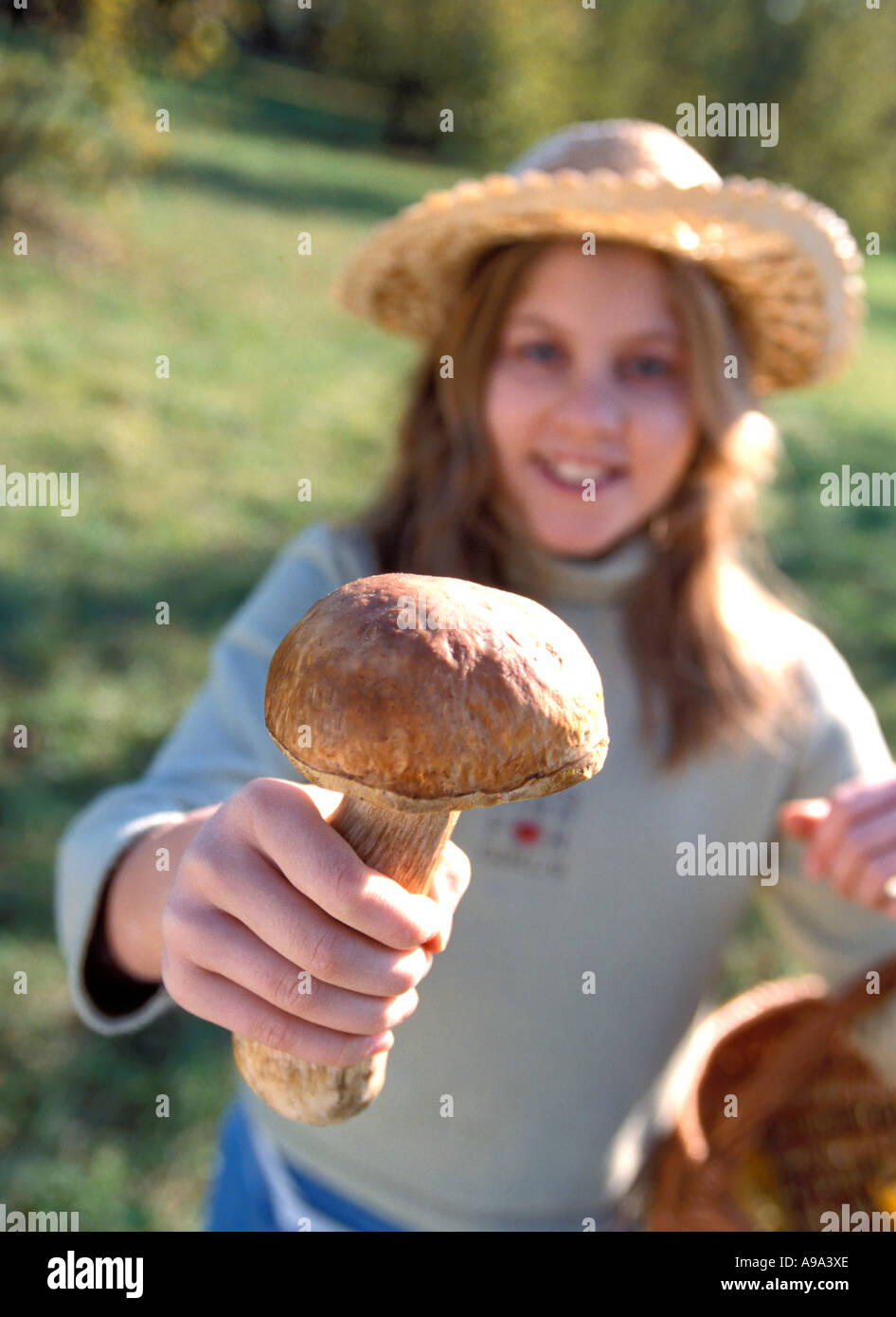 Girl in straw hat with mushroom Stock Photo - Alamy