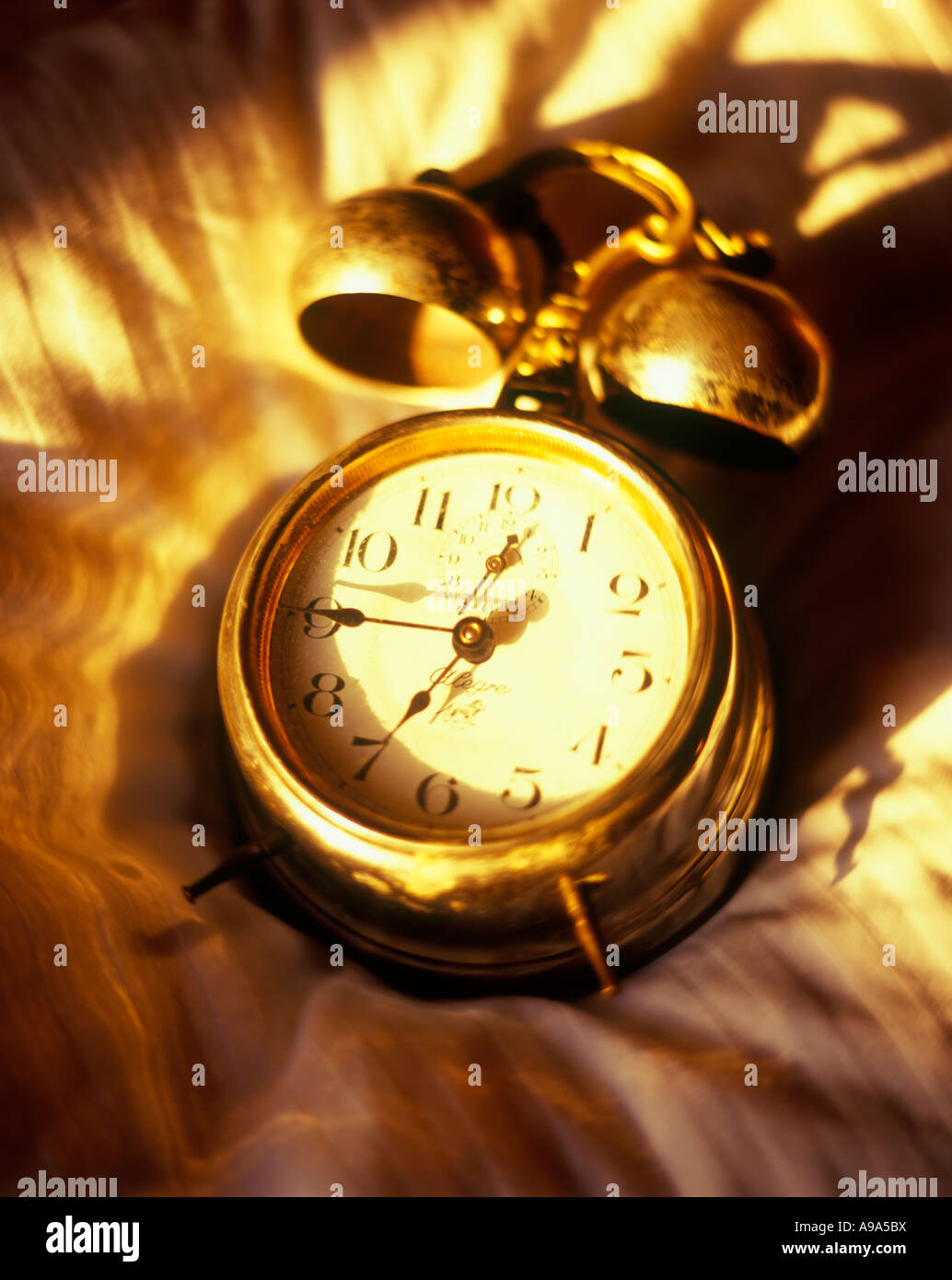 CLASSIC ANTIQUE OLD FASHIONED WINDUP ALARM CLOCK LAYING ON BED Stock ...