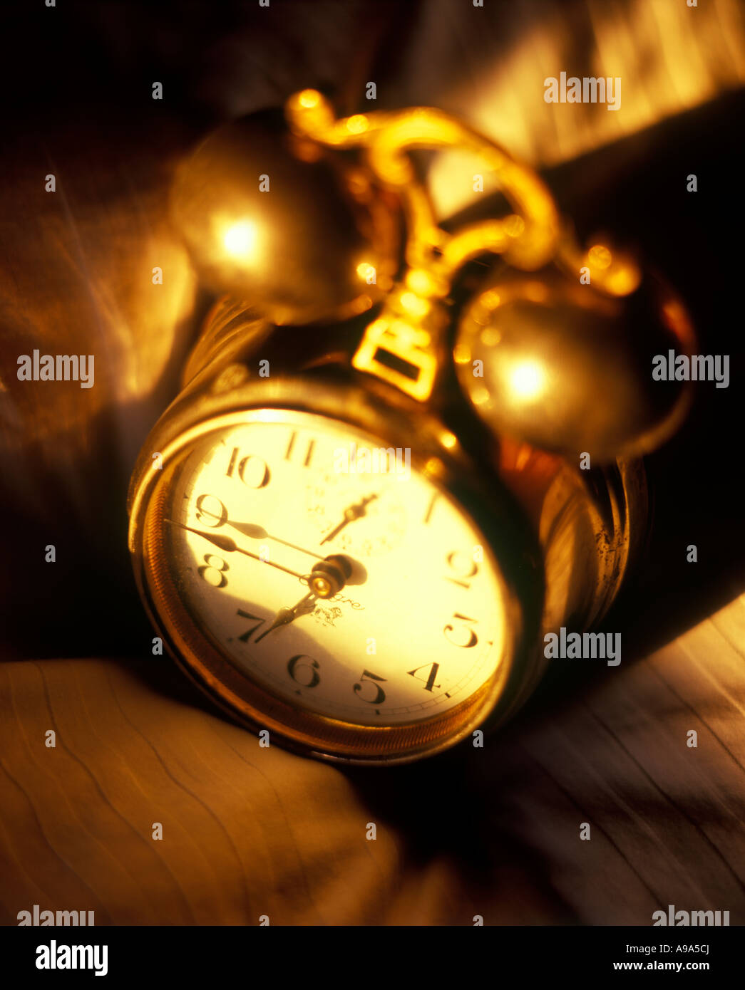 CLASSIC ANTIQUE OLD FASHIONED WINDUP ALARM CLOCK LAYING ON BED Stock ...