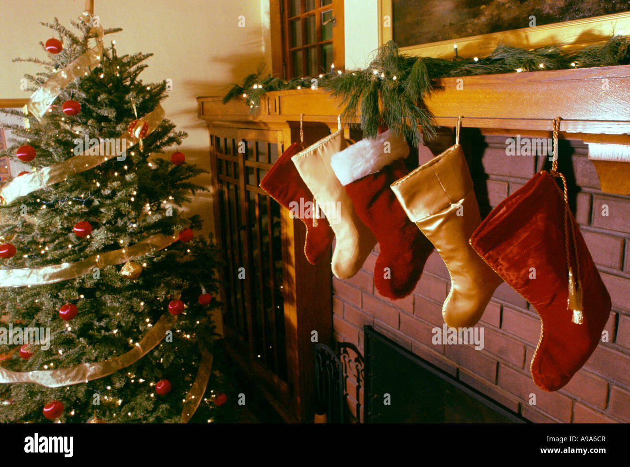 LINE OF STOCKINGS HANGING FROM ABOVE FIREPLACE IN CHRISTMAS ROOM USA ...