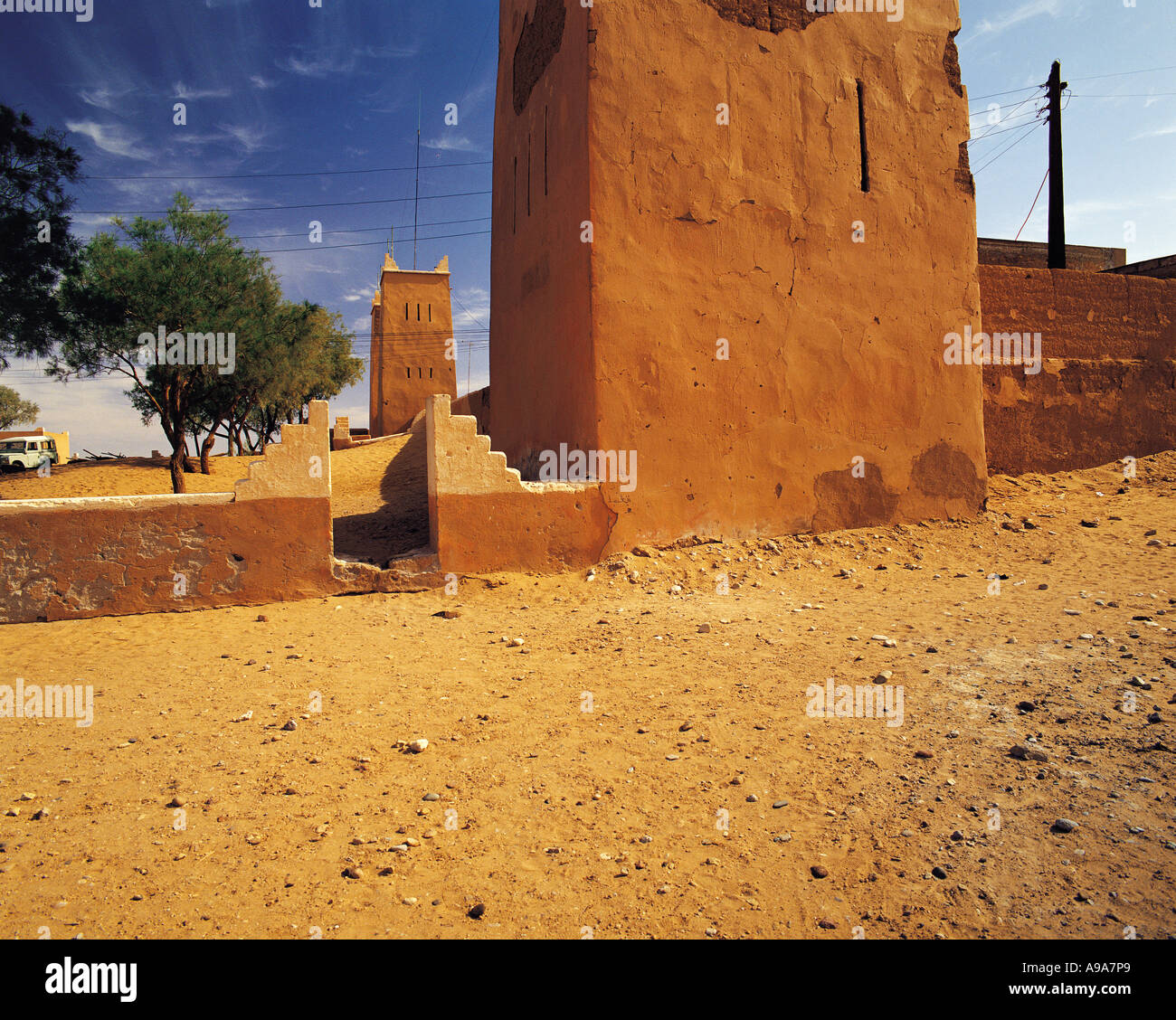 Mud built buildings in a dusty sandy street in the casbah of M'hamid ...