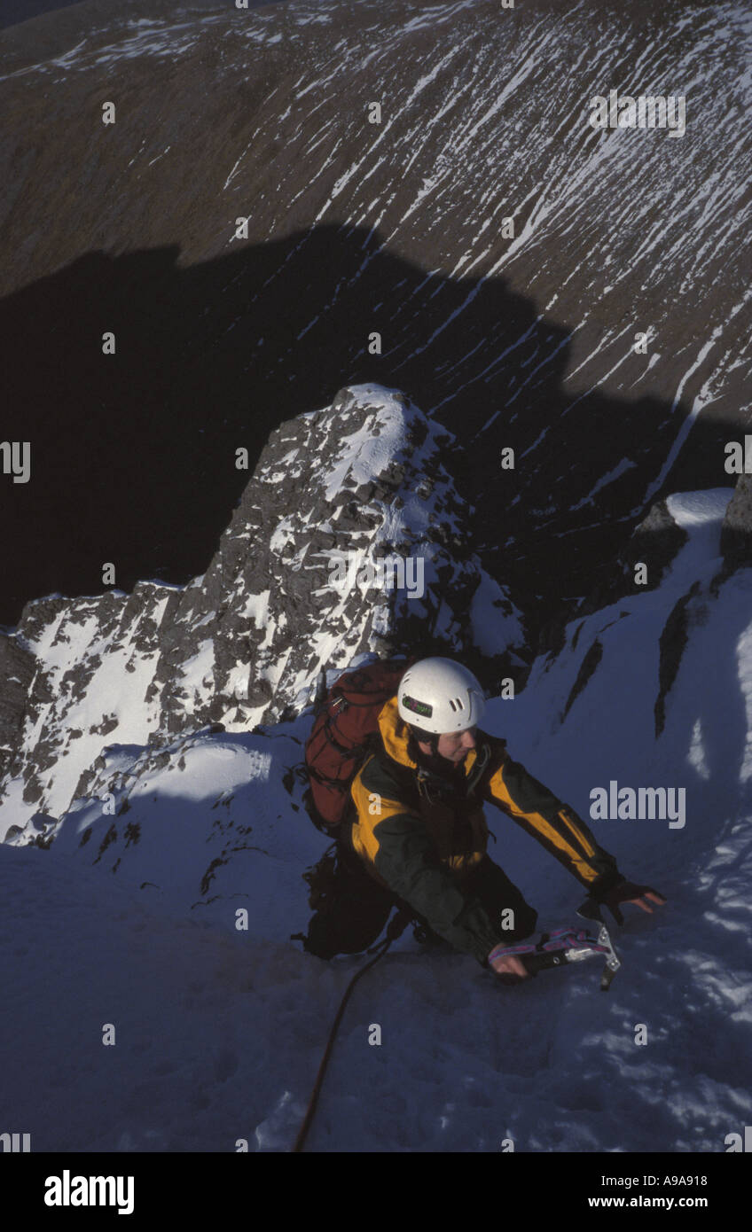 Climber approaching the summit of Ben Nevis via Tower Ridge in winter ...