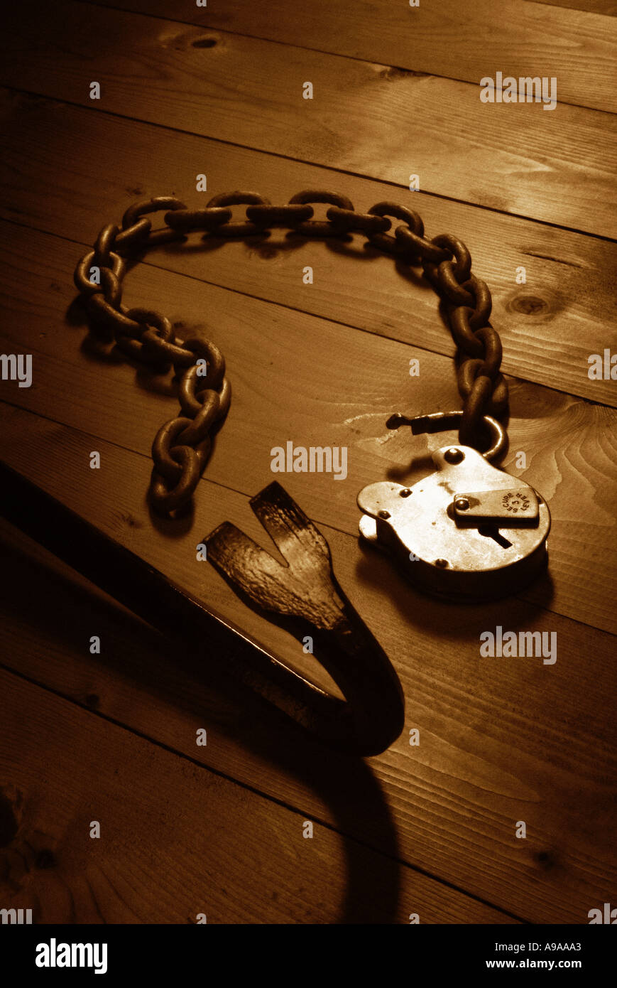 Broken padlock chain and crowbar jemmy illustrating security breach ...