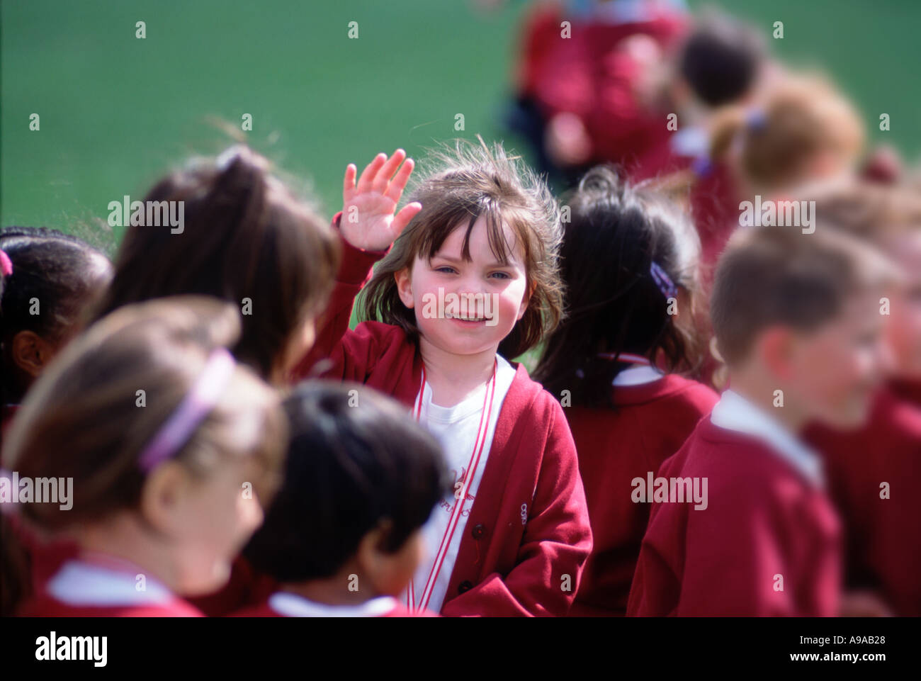Five year old child waves to camera at primary school funrun nr London ...