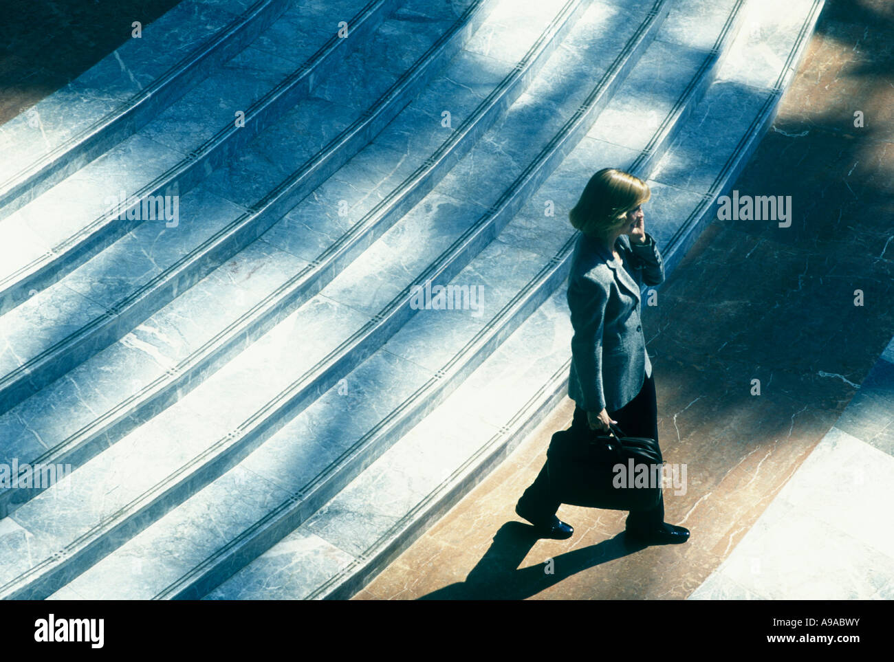 FEMALE OFFICE WORKER WALKING DOWN STEPS WITH CELLPHONE MOBILE TELEPHONE ...