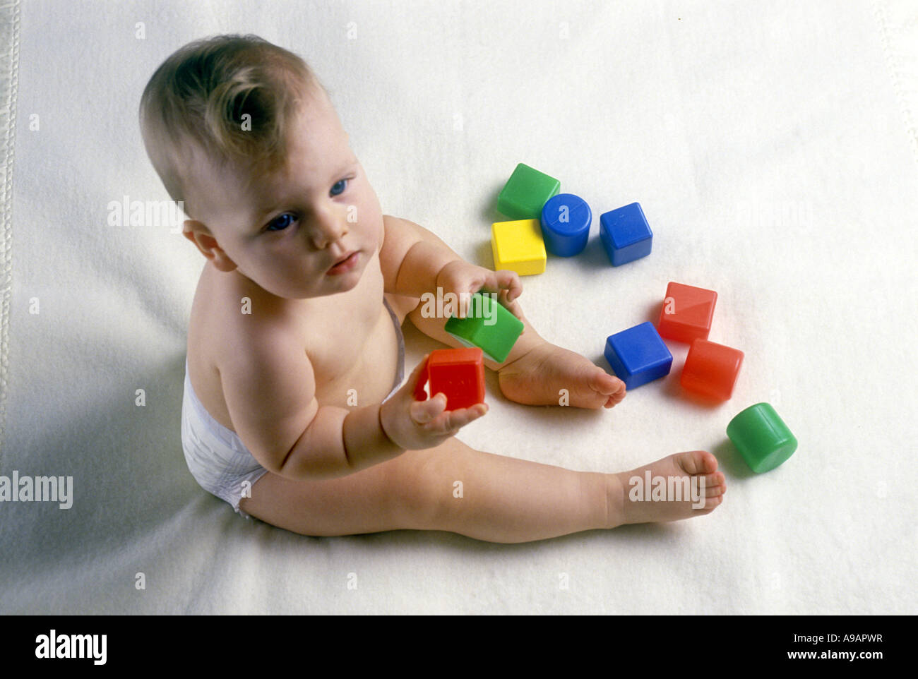 INFANT BABY PLAYING WITH COLORED TOY BUILDING BLOCKS Stock Photo - Alamy