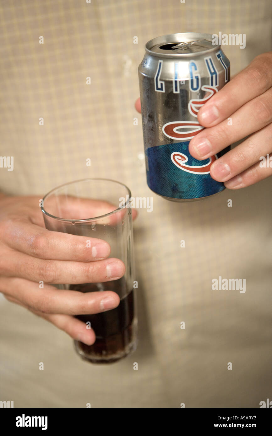 Man in casual clothes holding can of light cola Stock Photo - Alamy