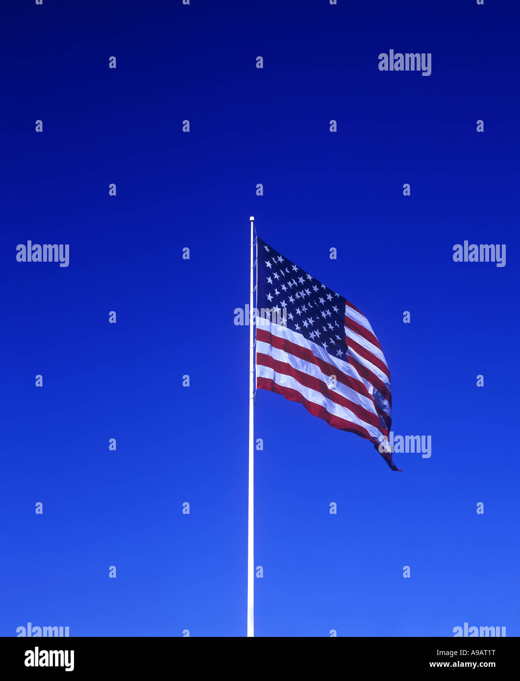 RIPPLING UNITED STATES FLAG FLYING ON FLAGPOLE WITH BLUE SKY Stock ...